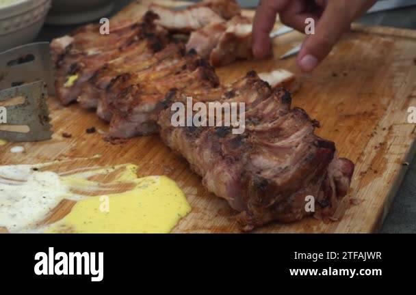 close-up hands grabbing several pieces of grilled pork rib meat to eat ...