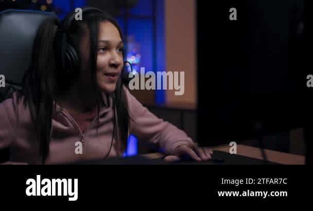 Shot from behind computer monitor of focused gamer. Girl has gaming ...