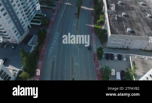 Birds eye view of wide multilane road in town, tilt up reveal high rise ...