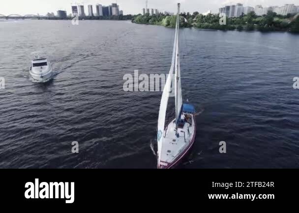 Luxury motor yacht and sailing yacht ride near each other on the river ...