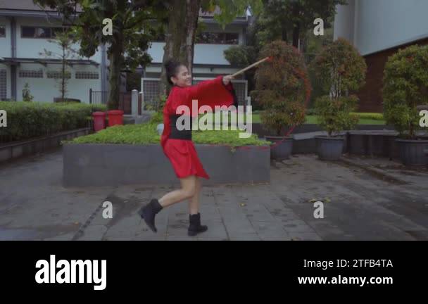 A Chinese Kids in a red costume having fun while playing with the rope ...
