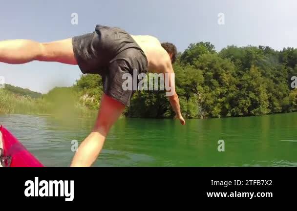 Man jumping into water from canoe while his girlfriend laughing in a ...
