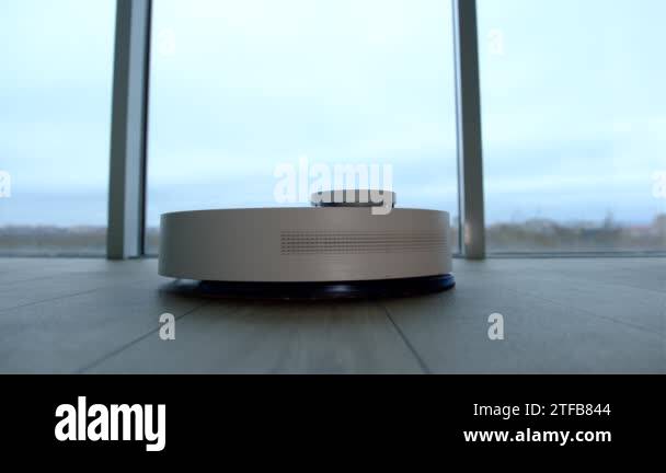 Robot vacuum cleaner vacuuming the floor. Turning around. Smart home ...