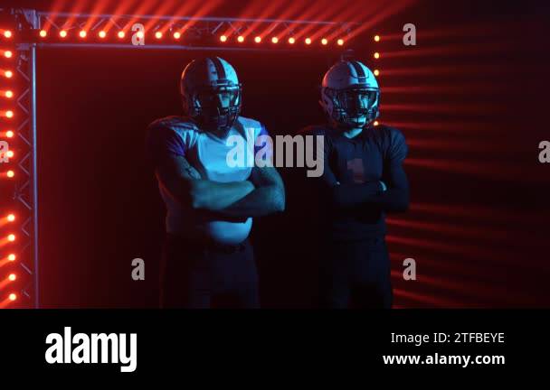 Two confident professional quarterbacks stand on the field against a ...