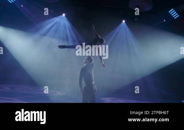 Figure skaters pair perform stationary rotational overhead lift. Man ...