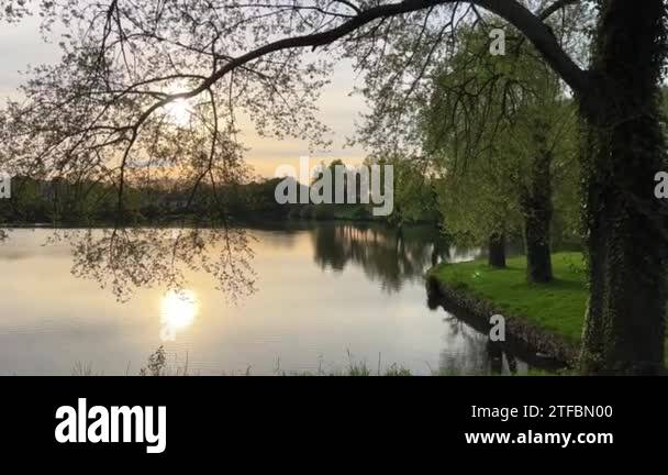 Park with lake reflection of the sun in the Water city in Paris Torcy ...