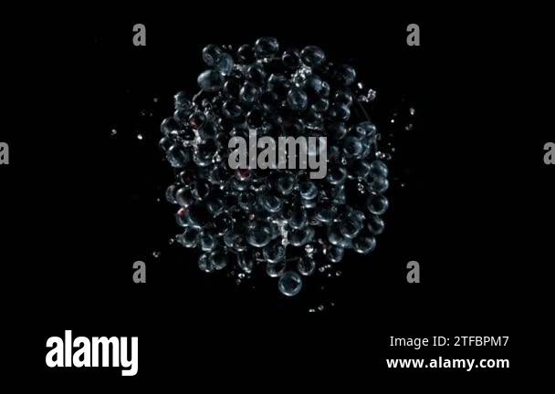 Super slow motion of rotating blueberries with splashing water, top ...