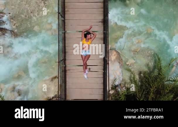 Overhead Shot Of Young Girl Laying Down Sunbathing On Hanging Bridge ...