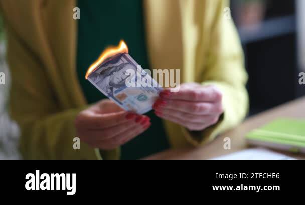 Burning one hundred dollar bill in female hands. Burning money concept ...