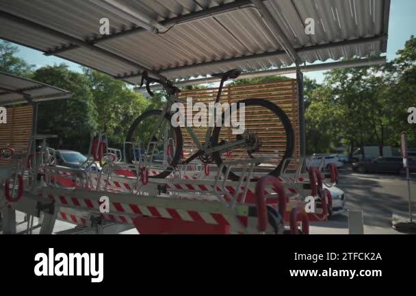 A man parks his bicycle in a modern urban multi-level bike parking lot ...