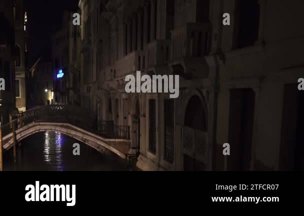 Venice, Italy night view of empty pedestrian bridge on narrow canal ...