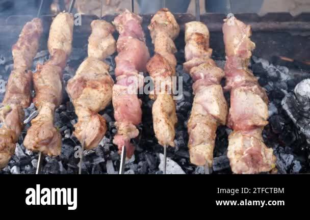 a man roasts meat on a fire. Close-up of hands and barbecue. Grilling ...