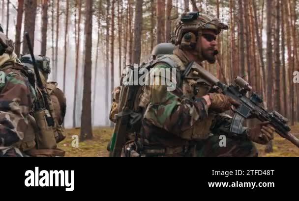 Four Fully Equipped Middle - Aged Soldiers Wearing Camouflage Uniform ...