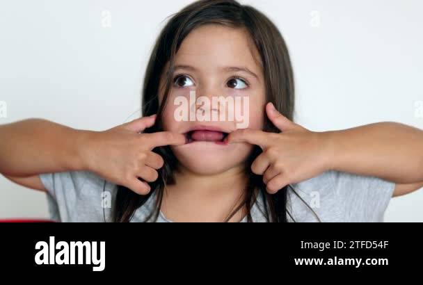 Little girl grimacing, sticking ongue out. Child grimace making funny ...