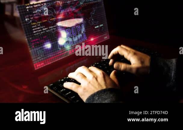 Hacker typing on the keyboard with propaganda on virtual display on ...