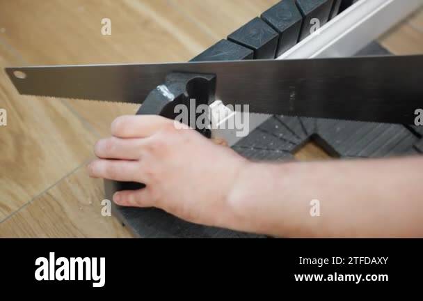 Top view shot of skirting board cutting, craftsman using hand saw and ...