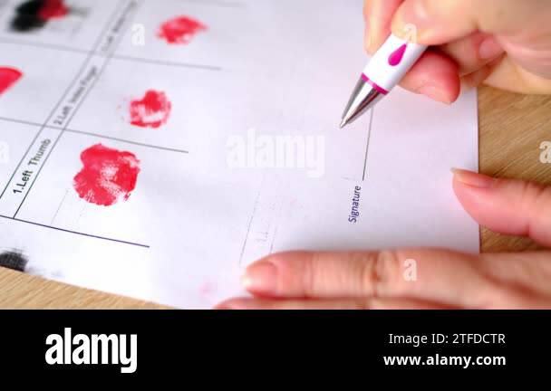 close-up of finger makes fingerprint using special red paint, documents ...