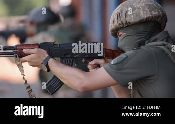 Armed man unloading machine gun with machine gun in his hands, soldier ...