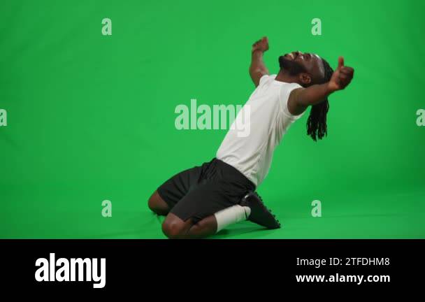 Wide shot excited African American footballer rejoicing goal on green ...