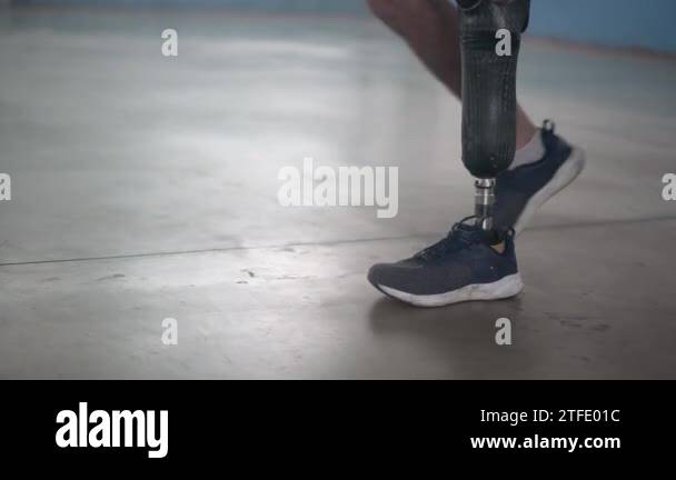 Disabled person walking with his prosthetic leg indoors. Amputee man ...