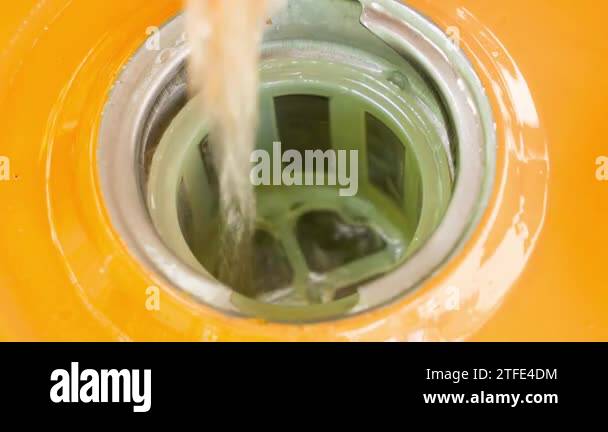 Fuel is poured into the fuel tank of a yellow gas generator from a ...
