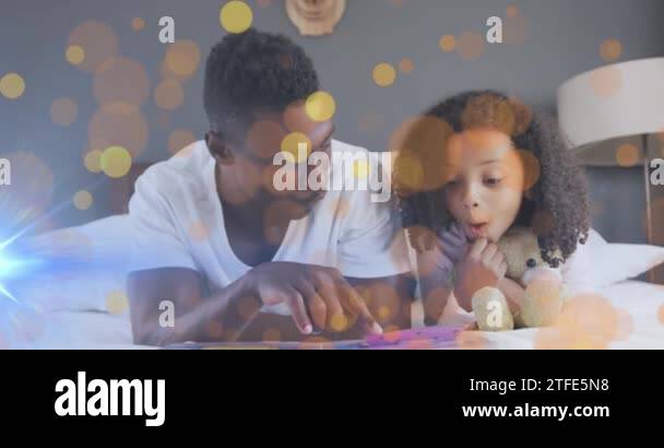Animation of spots over african american father with daughter smiling ...
