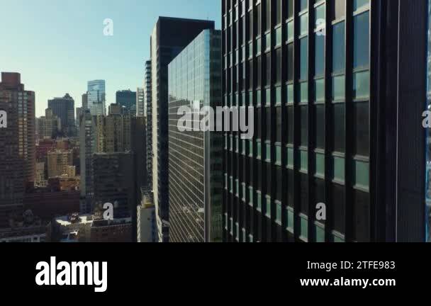 Ascending footage along glossy wall of high rise building. Revealing ...