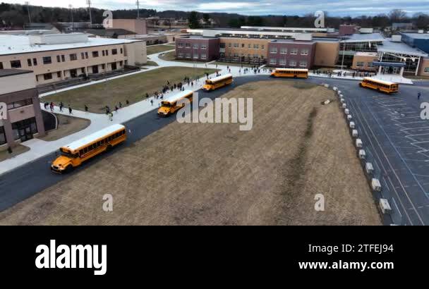 High school campus. Aerial of line up of yellow school bus vehicles ...