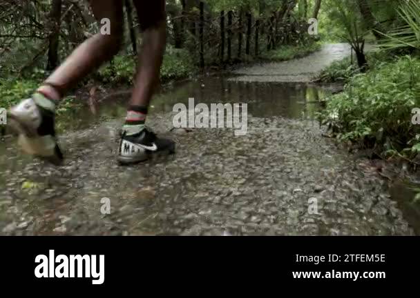 Slow motion video of little boy wearing yellow boots running jumping in ...
