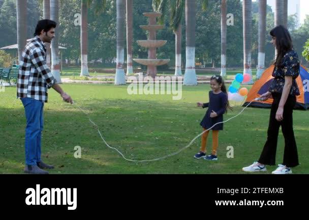 A little schoolgirl practices jumping over a skipping rope - an outdoor ...