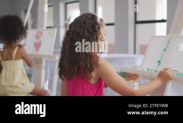 Video of back of diverse girls painting during art lessons at school ...