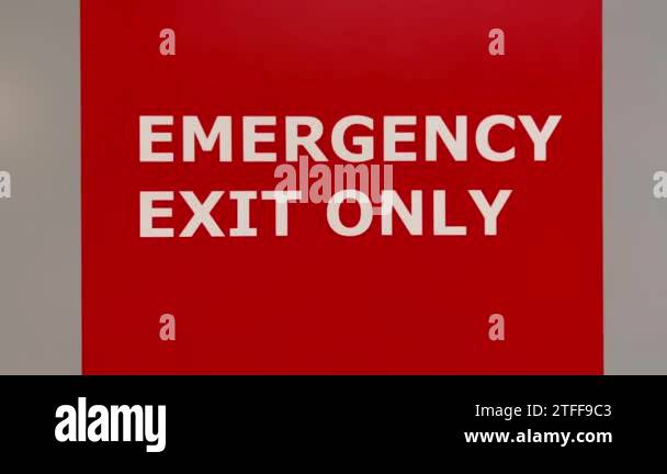 Emergency Exit only, is stated on a sign, poster, or banner with an ...
