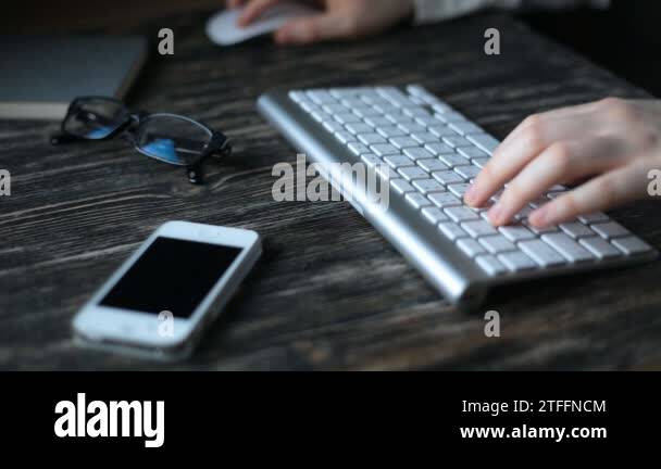 A modern workplace. Night work. A man sits at a computer and types on ...