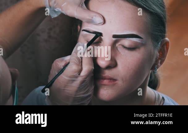 Building the shape of the eyebrows. Beauty salon. Eyebrow master dyes ...