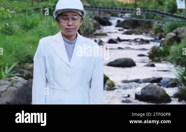 Environmental engineer wearing a helmet makes a thumbs-up gesture and ...