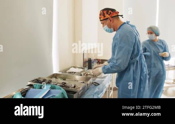 Operating Room of Surgical Table with Instruments, Doctor Picks up ...