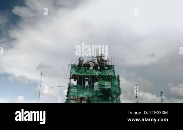 Up-down panning shot of a Khmer statue being built in the middle of a ...
