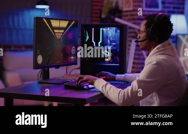 Handheld shot of african american man using pc gaming setup relaxing ...