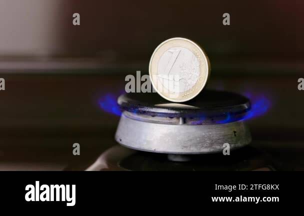 gas stove burner with one euro coin standing vertically on top, burning ...