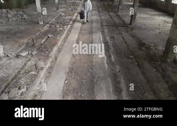 A forensic scientist with a briefcase walks down an empty hall to the ...