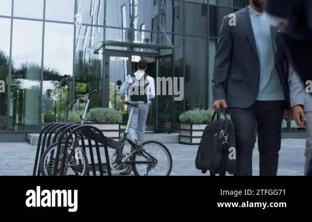 Corporate people walking enter office building. Shared parking at ...