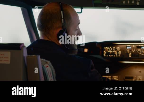 Airplane captain pushing buttons to fix altitude and longitude, flying ...