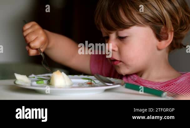 Little boy using fork eating melon fruit. Child eating healthy food ...