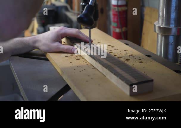 Luthier's hands drilling holes in fretboard for fretmarkers with drill ...