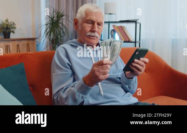 Planning family budget. Smiling senior old grandfather counting money ...