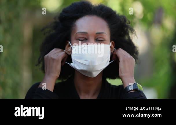 Black woman removing face mask feeling relief. African woman taking off ...