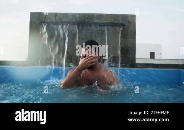 a man with a beard and chest hairs bathing in a pool of a pool in a ...