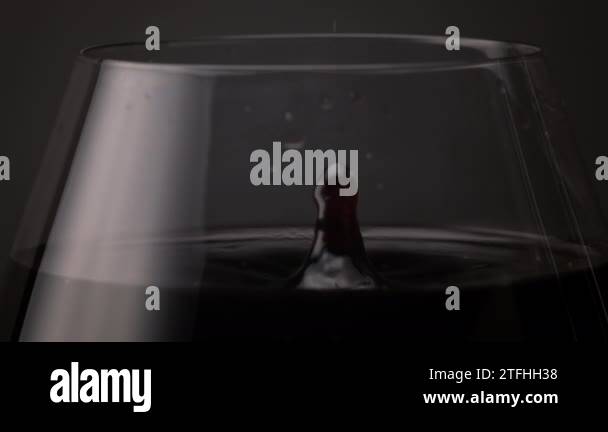 Delicious red wine dripping glass in super slow motion close up. Smooth ...