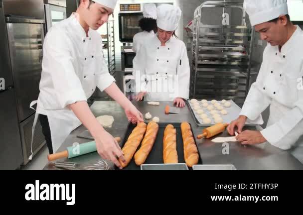 Multiracial professional gourmet team, four chefs in white cook ...