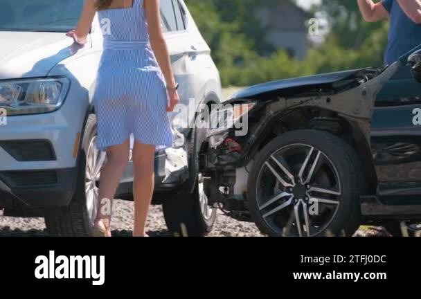 Angry woman and man drivers of heavily damaged vehicles arguing who is ...